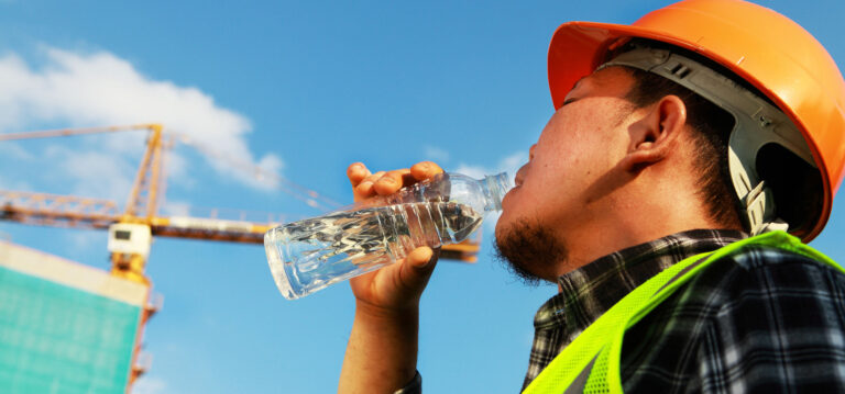 construction worker drinking water on a location site - MarathonHR, LLC